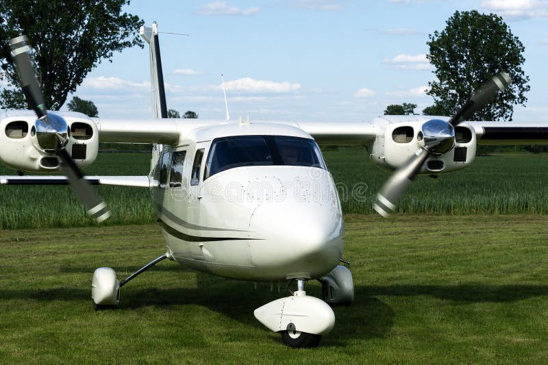 A White Twin-engine Plane Standing on a Grassy Airfield Stock Photo ...