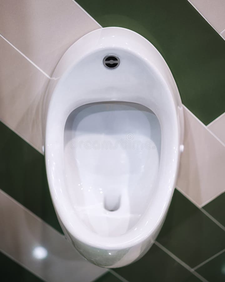 A White Urinal on a Green-and-white Tiled Wall Stock Photo - Image of ...
