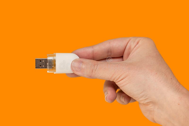 White USB Flash Drive on Hand with Isolated Orange Background Stock ...