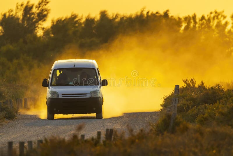 White Van Driving on Dusty Road at Sunset Stock Photo - Image of ...