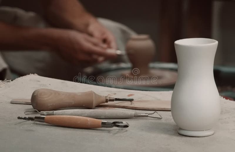 White Vase on Table. Potter& X27;s Tools. Potter& X27;s Hands on a ...
