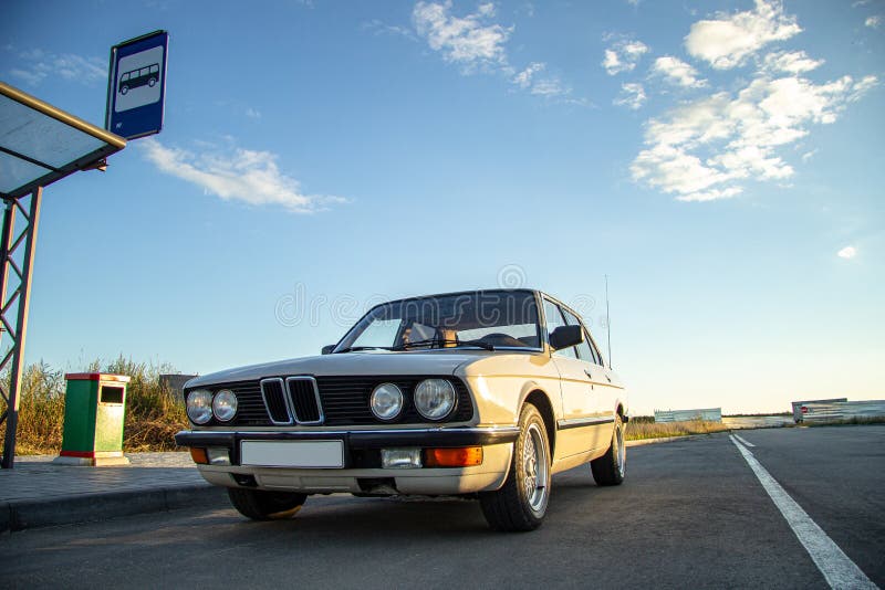 White Vintage Classic Car with Round Headlights with the Blue Sky in ...
