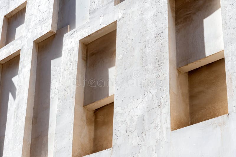 White Wall with Recessed Windows Creates an Abstract Pattern of Light ...