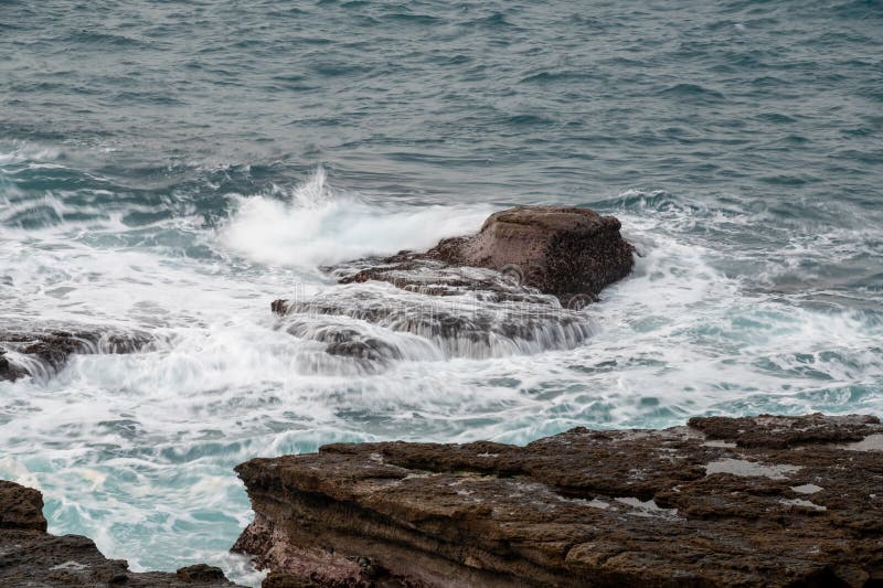 White Waves Lapping on the Rocks. a Symbol of Hard Work and Strength ...