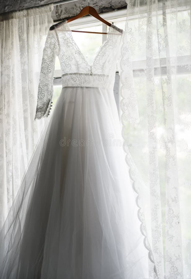 White Wedding Dress Hanging by the Window Stock Image - Image of window ...