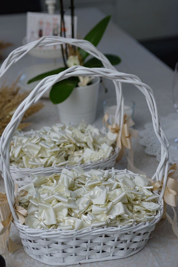 White Wicker Baskets Filled with Cream-colored Bows on a Table with a ...