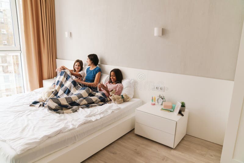 White Woman and Her Daughters Laughing while Resting on Bed Stock Image ...