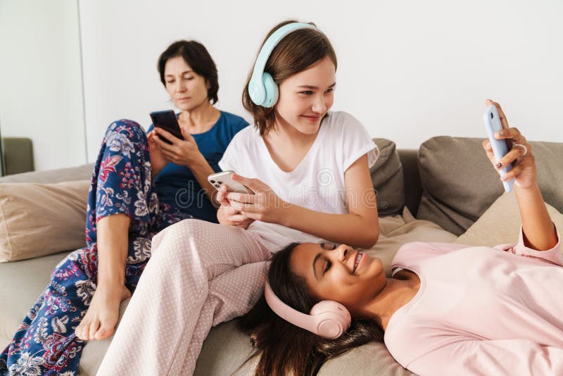 White Woman and Her Daughters Using Gadgets while Resting on Couch ...