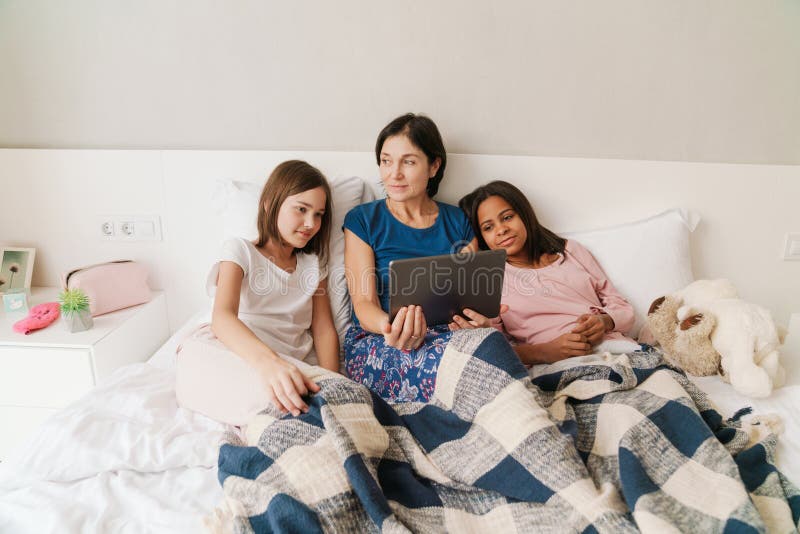 White Woman and Her Daughters Using Tablet Computer while Resting on ...