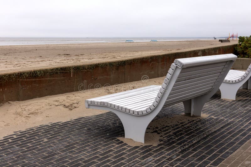 A White Wooden Bench on the Shore of the Beach on a Cobblestone ...