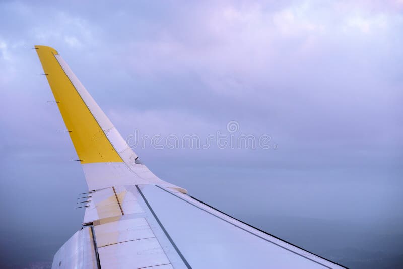 White and Yellow Wing of a Plane with the Beautiful Clouds in the ...