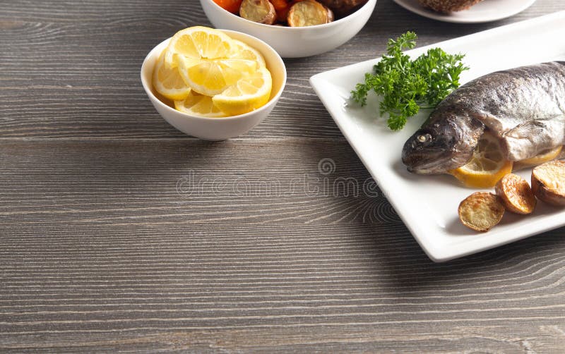 Whole Baked Rainbow Trout on a Table Set for Dinner Stock Photo - Image ...