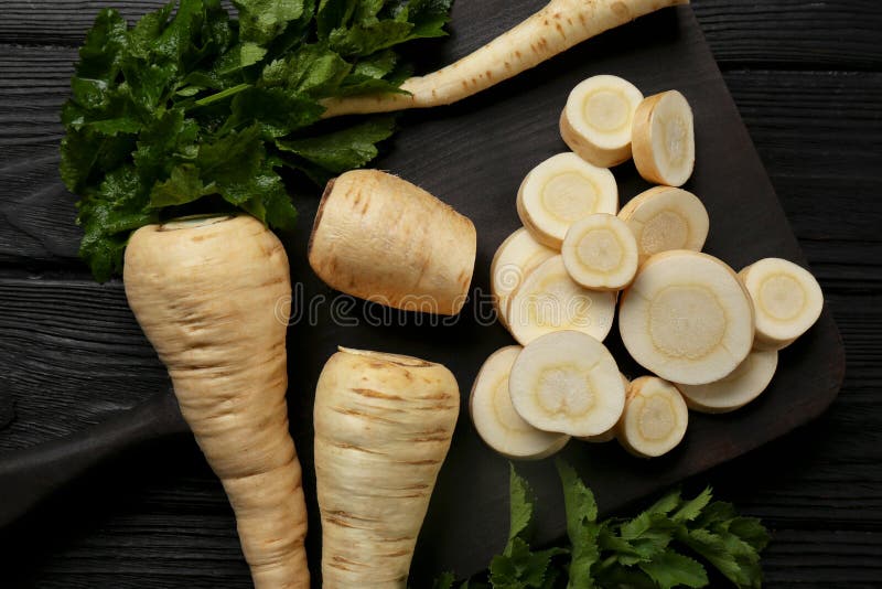 Whole and Cut Parsnips on Black Wooden Table, Flat Lay Stock Photo ...