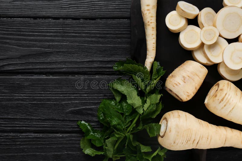 Whole and Cut Parsnips on Black Wooden Table, Flat Lay. Space for Text ...