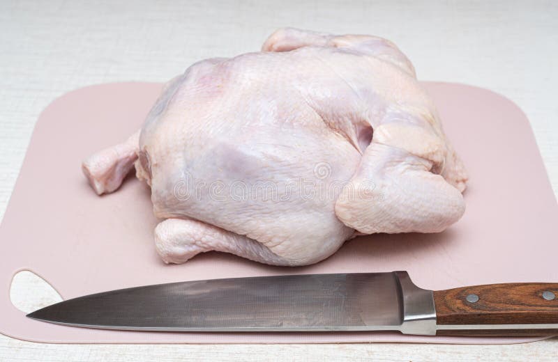 Whole Fresh Chicken and a Kitchen Knife on a Cutting Board. Stock Image ...