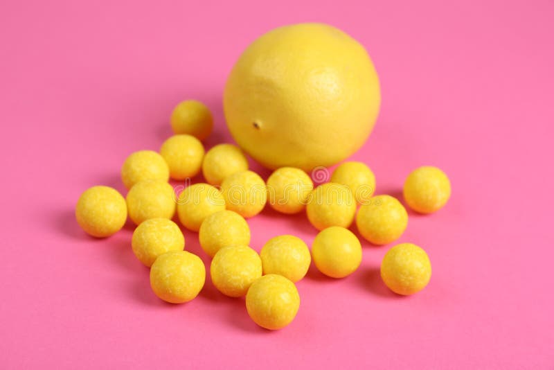 Whole Fresh Lemon and Yellow Candies on Pink Background Stock Image ...