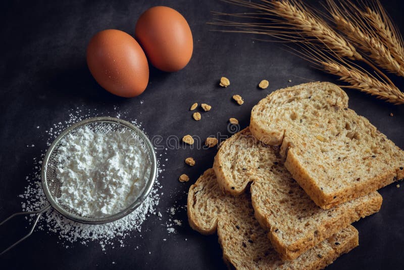 Whole Grain Bread, Flour and Egg on Dark Background Stock Image - Image ...