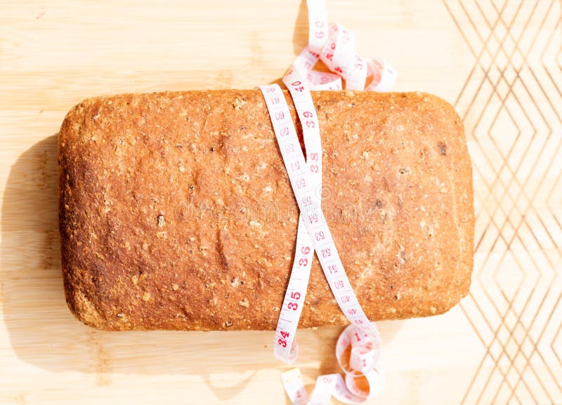 Whole Grain Bread Wrapped in a Measuring Tape on Board Stock Image ...