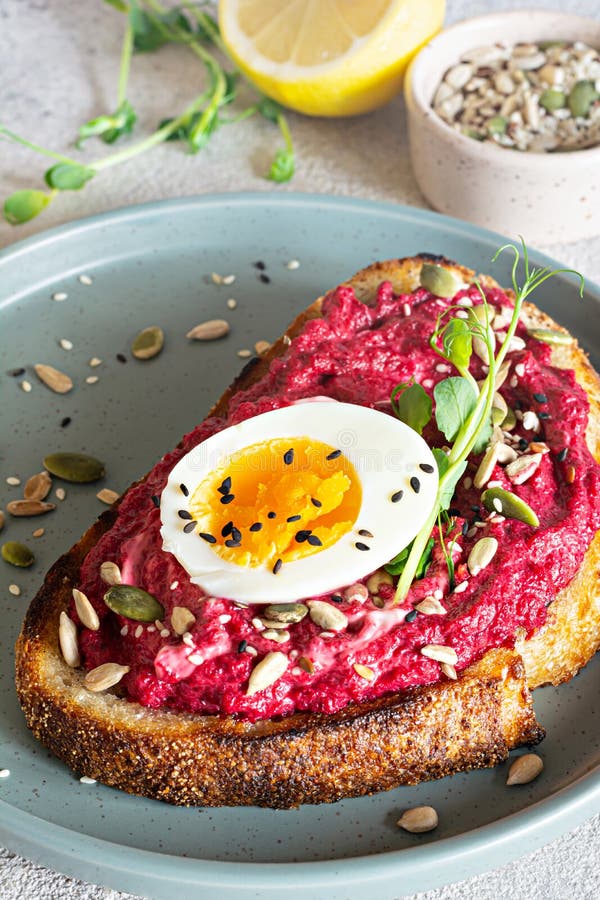 Whole Grain Toast with Beetroot Hummus, Seeds, Egg and Microgreens Sprouted Pea Sprouts on a ...