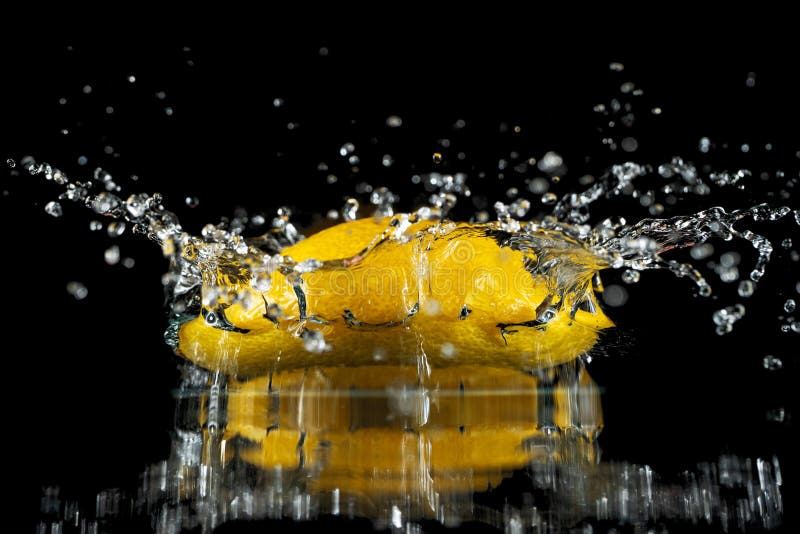 A Whole Lemon Falls into the Water on a Black Background of Frozen ...
