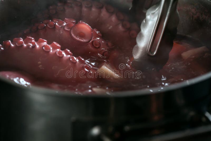 Whole Octopus Boiling in the the Pot Filled with Water and Vegetables ...