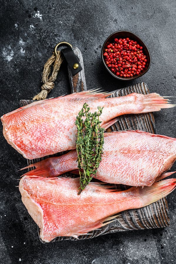 Whole Raw Red Snapper Fish on a Cutting Board. Black Background Stock ...