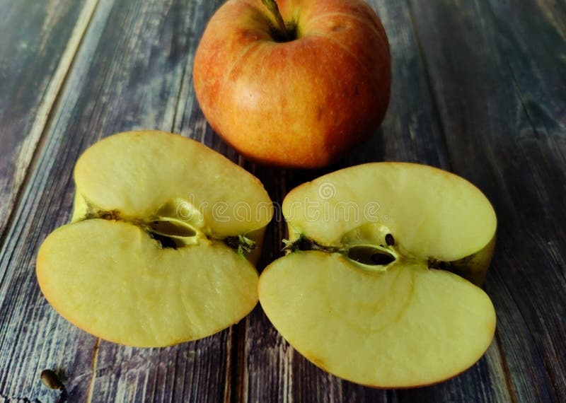 Whole Red Apple and Two Half on a Wooden Table. Close-up Stock Photo ...
