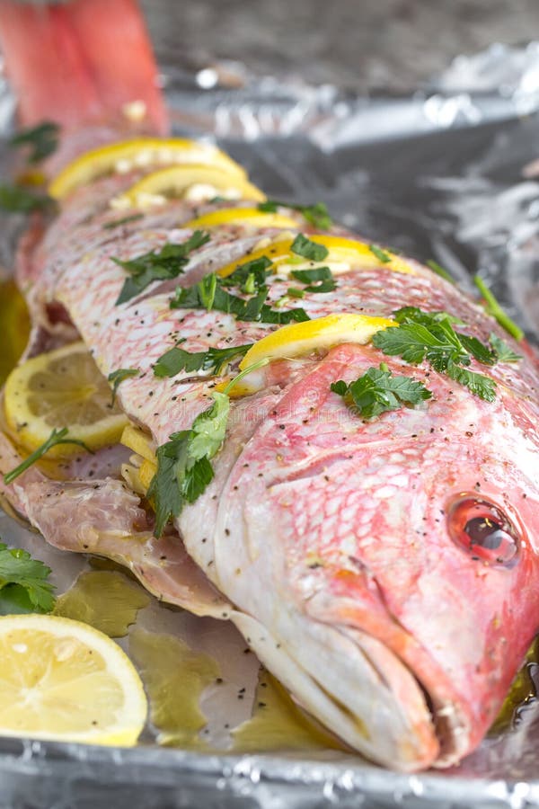 Whole Red Snapper with Lemon Slices and Parsley Stock Photo - Image of ...