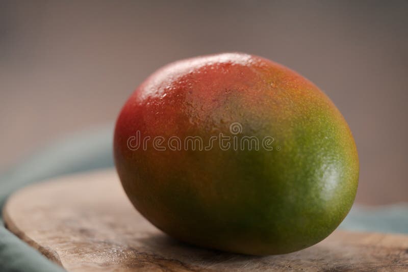 Whole Ripe Red Mango on Olive Wood Board Stock Image - Image of table ...