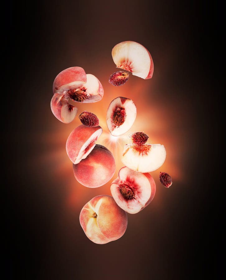 Whole and Sliced Fresh Peaches in the Air with Flash of Light in the ...