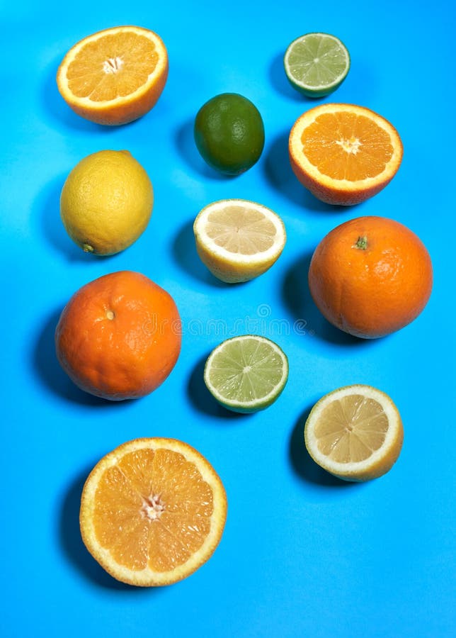 Whole and Split Oranges Limes and Lemons with Skin on a Blue Background ...