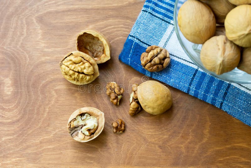 Whole Walnuts and Walnut Kernel Halves without Shell on a Dark Wooden ...