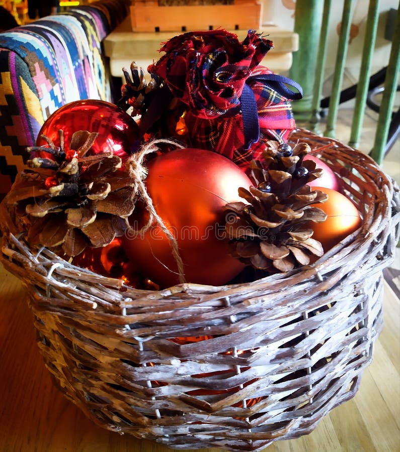 A Wicker Basket Containing Pine Cones, Christmas Tree Decorations and a ...