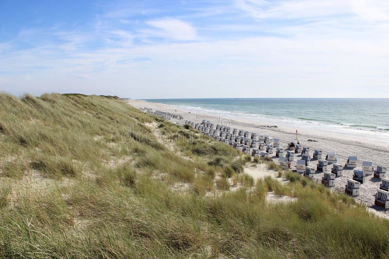 Wicker Beach Chairs Under a Grassy Dune at the Beach in Bright Sunlight ...