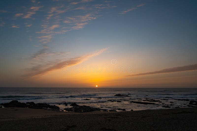 Wide Angle Beach at Sunset with Sun on Horizon and Wispy Clouds Stock ...