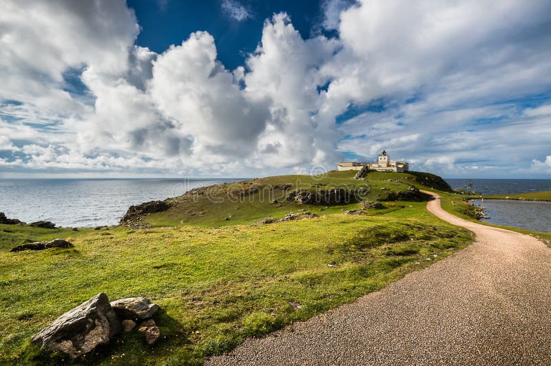 Scottish Landscape with a Distant Lighthouse Under Trailing Clouds ...