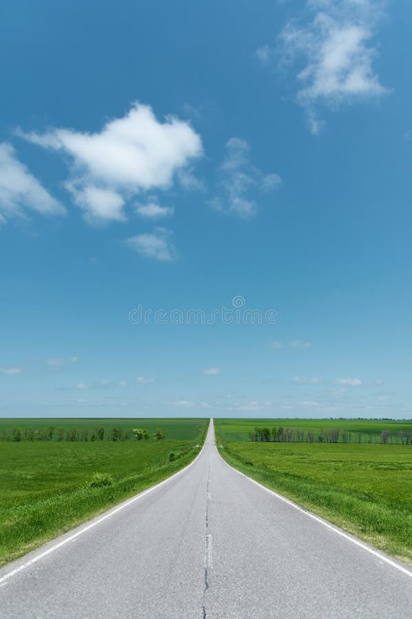 A Wide Asphalt Road between Green Fields Stock Photo - Image of blue ...