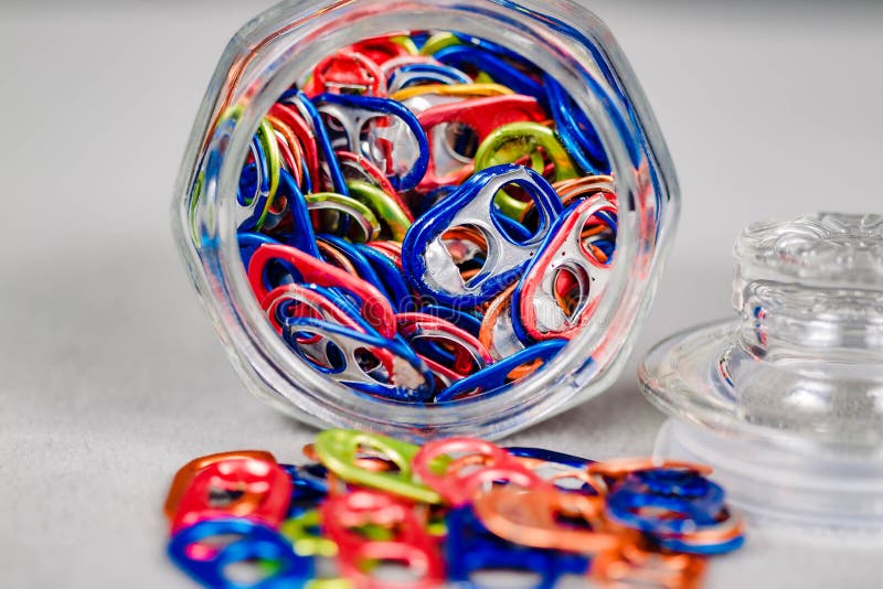 Wide Close Up View of a Jar of Multi Colored Can Pull Tabs Laying on it ...