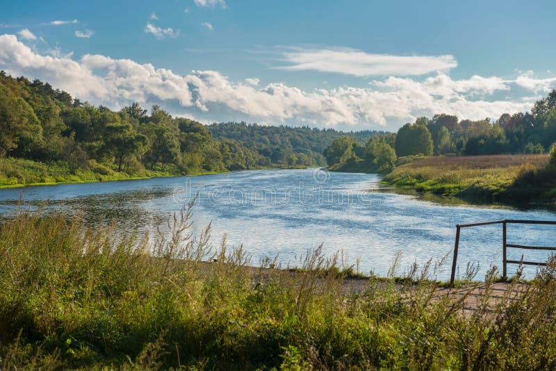 Wide river in green banks stock photo. Image of coniferous - 70491232