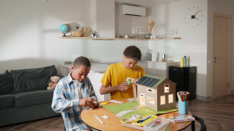 Wide Shot of African Brothers Working Together at Table, Assembling ...