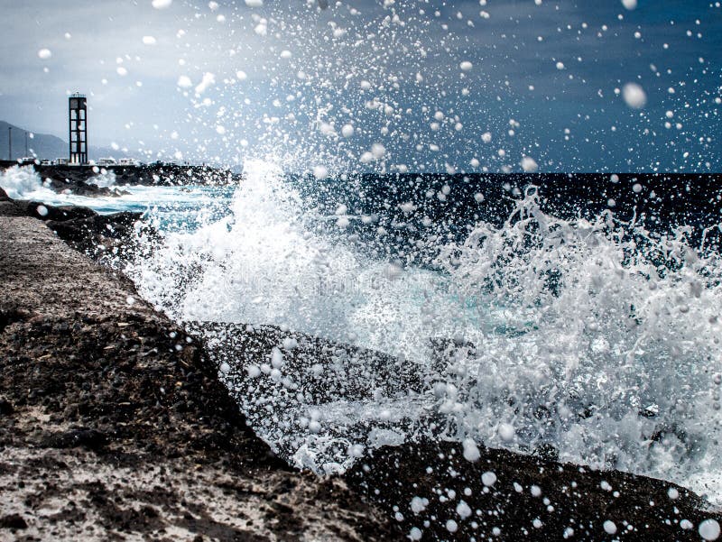Wide View Over the Breakwater To the Lighthouse with Crashing Waves ...