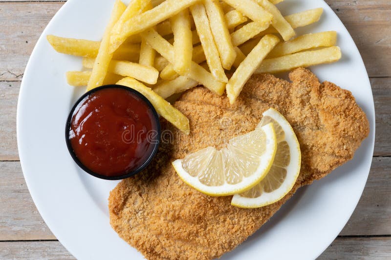 Wiener Schnitzel with Fried Potatoes on Wooedn Table Stock Photo ...