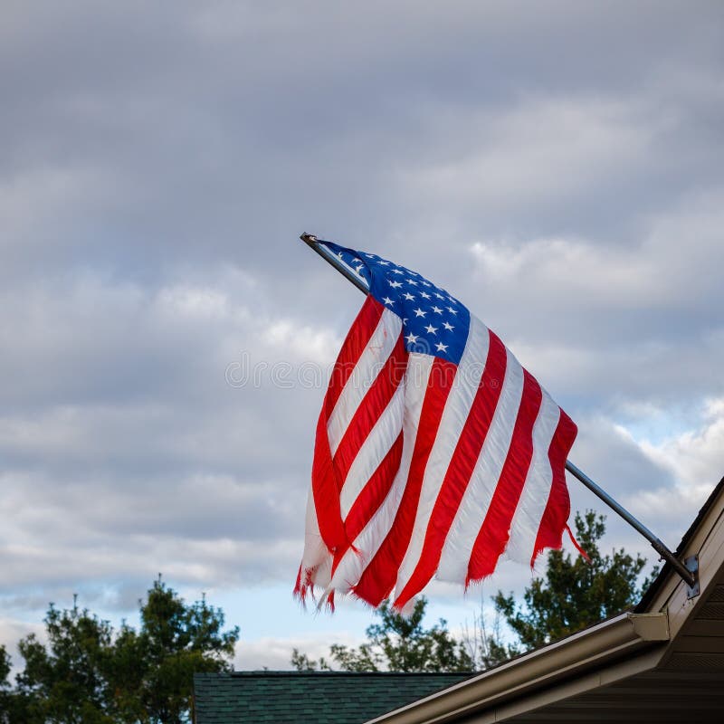 Wind Blown Tattered American Flag with a Cloudy Sky Background. Stock ... Wind Blown Tattered American Flag with a Cloudy Sky Background. Stock ...