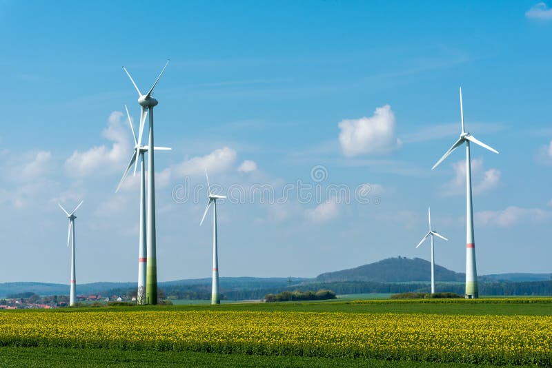 Wind Energy Plants in a Rapeseed Field Stock Photo - Image of cereal ...