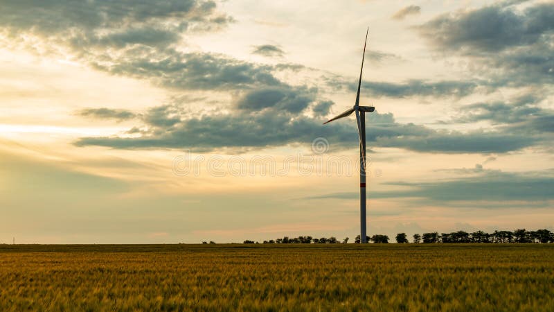 Wind Generator in Grass Field at Sunset Stock Photo - Image of ...