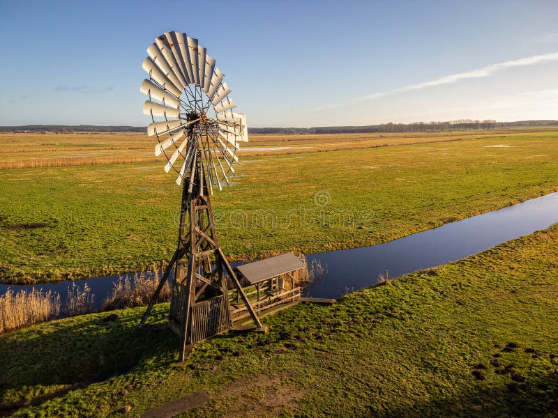 Wind Power Station Windmill on a River in the Middle of Fields and ...