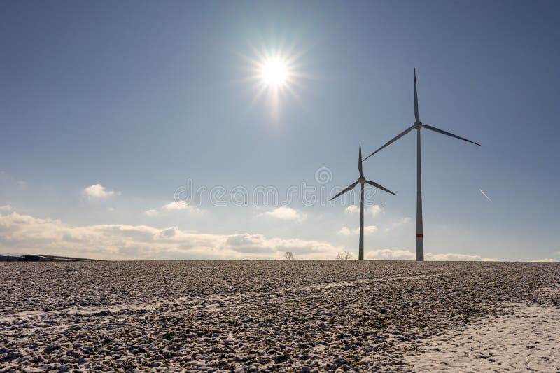 Wind Turbine in the Snow with Sun Star and Blue Sky Stock Photo - Image ...