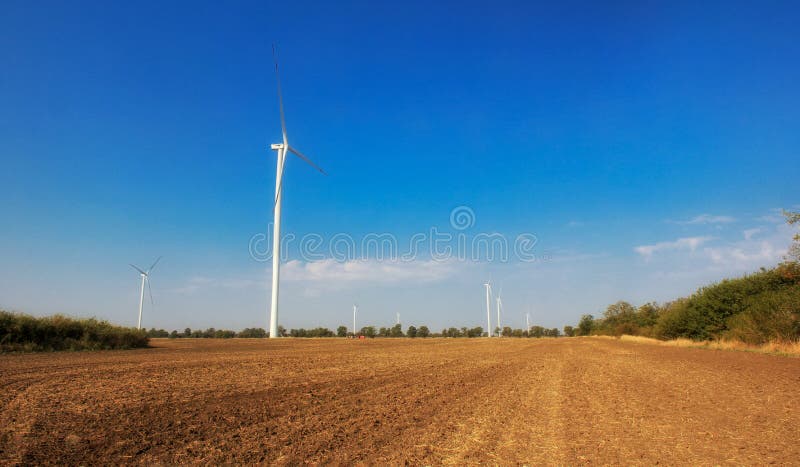 Wind Turbines on Field. Empty Field in Foreground, Blue Sky on ...
