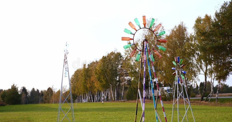 A Wind Wheel Made from Old Plastic Bottles Stands on a Green Lawn and ...