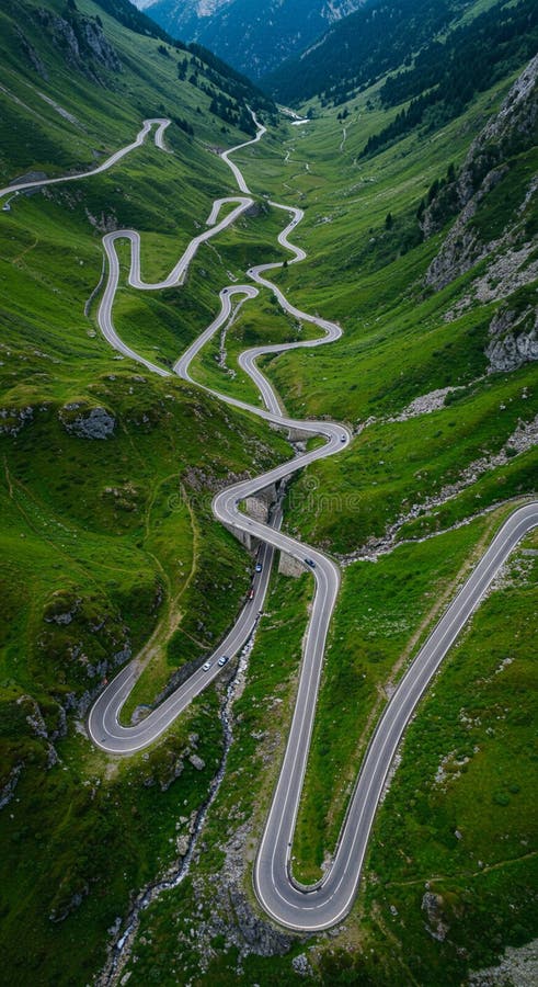 A Winding Mountain Road Cuts through Lush Green Hills and Rugged ...
